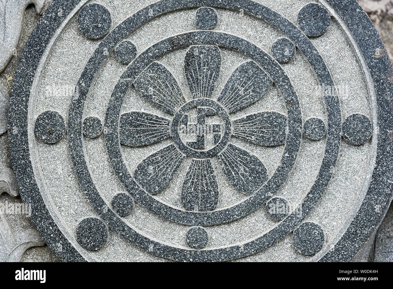 Stone carved radial design with Buddhist swastika symbol at the centre ...