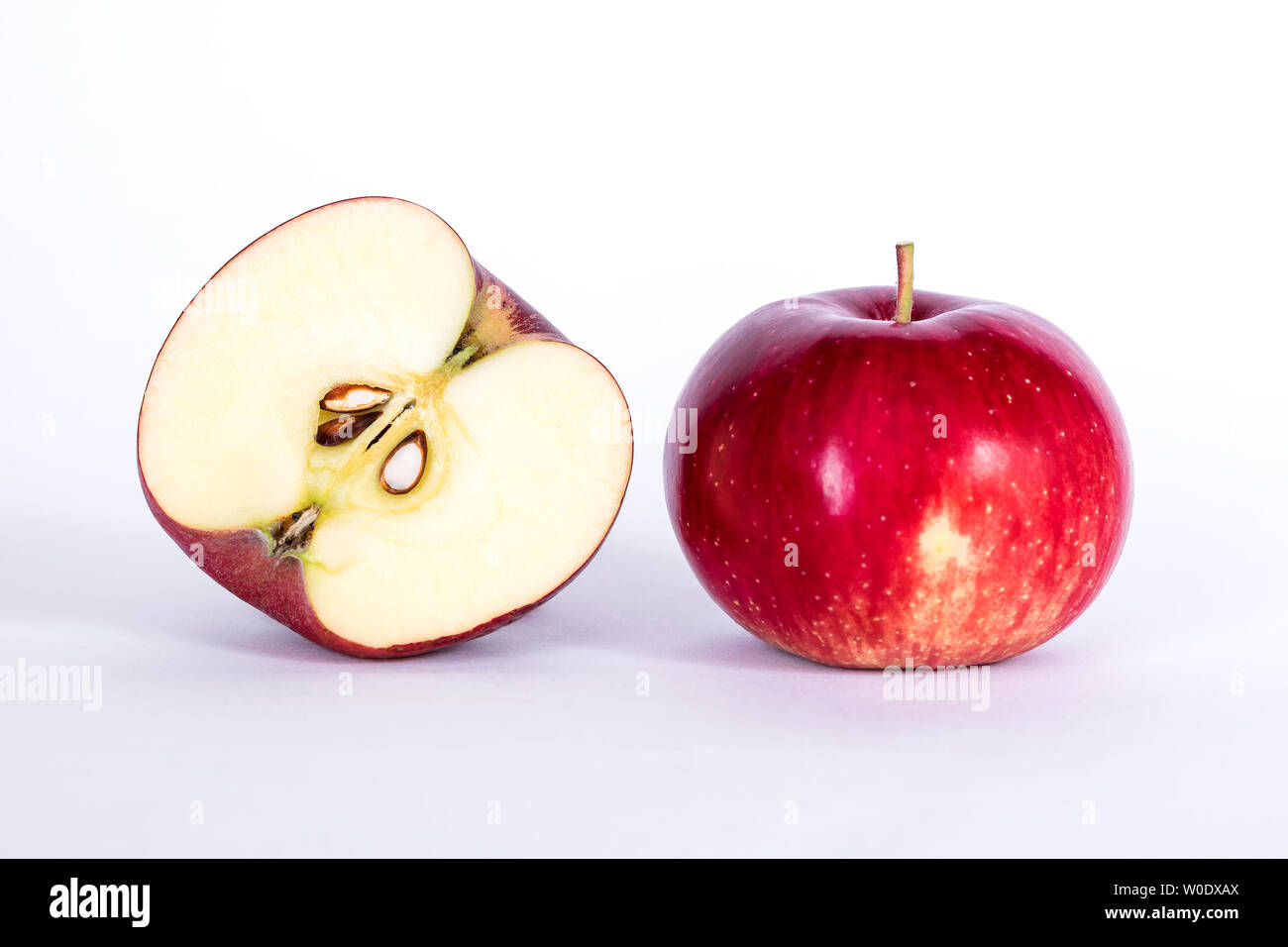 One whole apple and one half apple on a white background Stock Photo ...