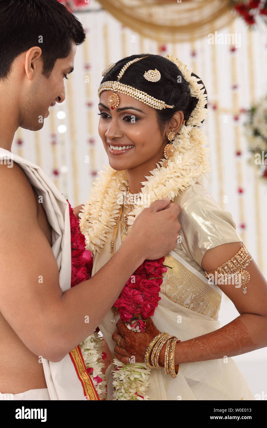 Indian couple performing mala badal ceremony in wedding mandap Stock ...