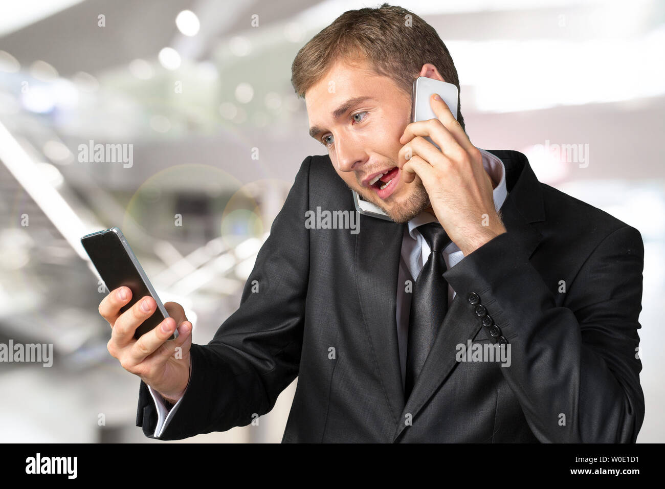 Busy young businessman talking the phone Stock Photo - Alamy