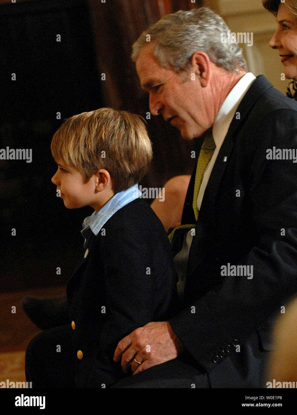 U.S. President George W. Bush sits with Elijah, 6, son of country ...