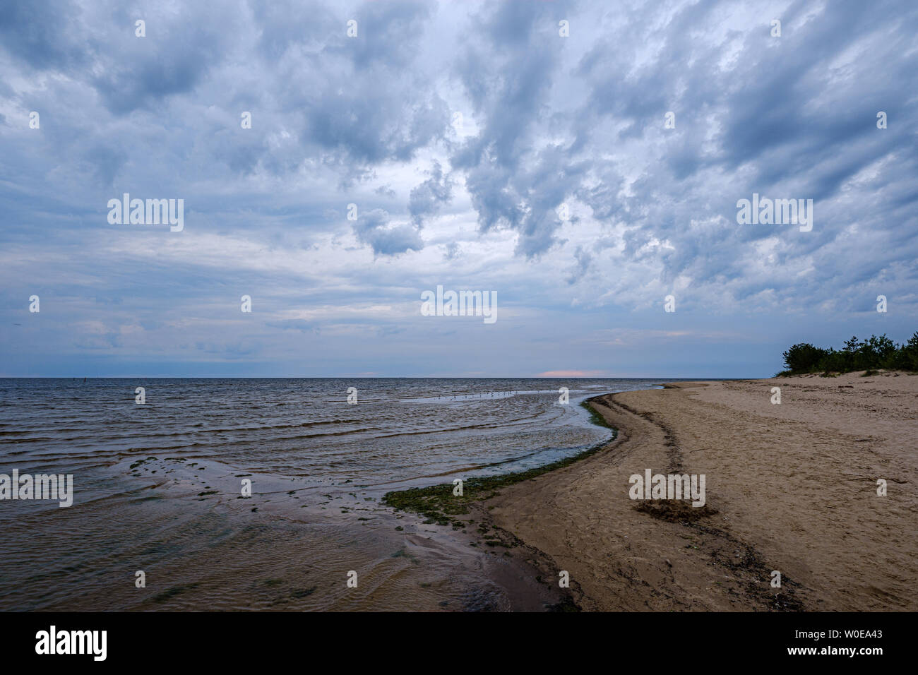 dramatic colorful clouds over sandy beach at the sea with blue sky and ...
