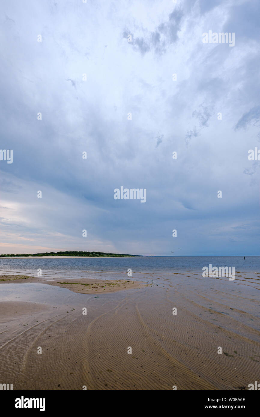 dramatic colorful clouds over sandy beach at the sea with blue sky and ...