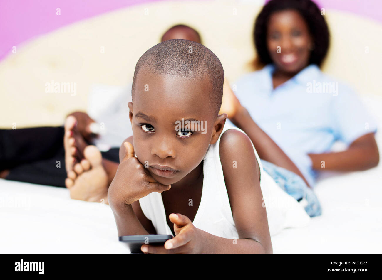 child plays with mobile phone of his parents who are watching in the ...