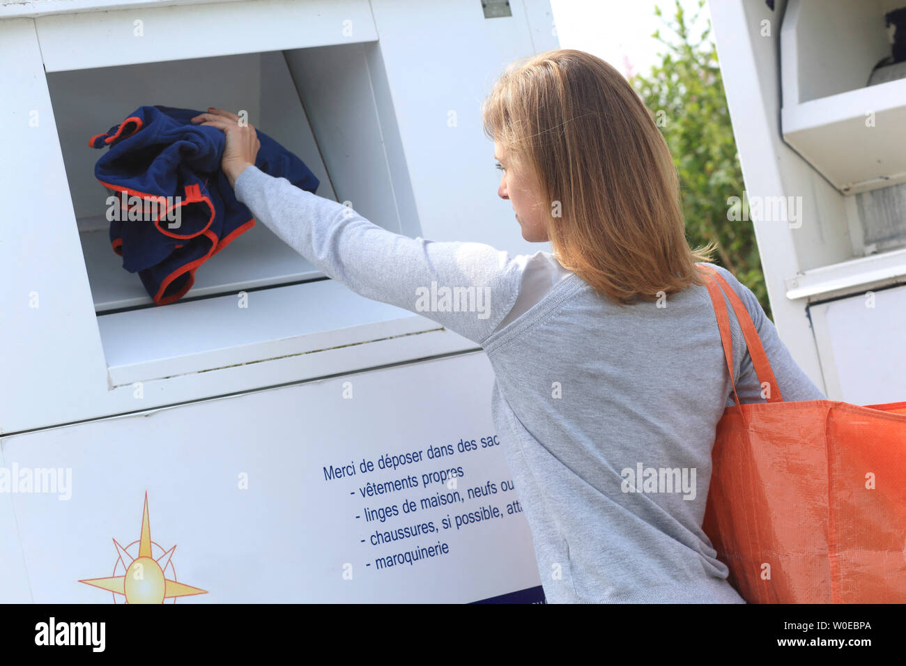 Young woman giving clothes Stock Photo - Alamy