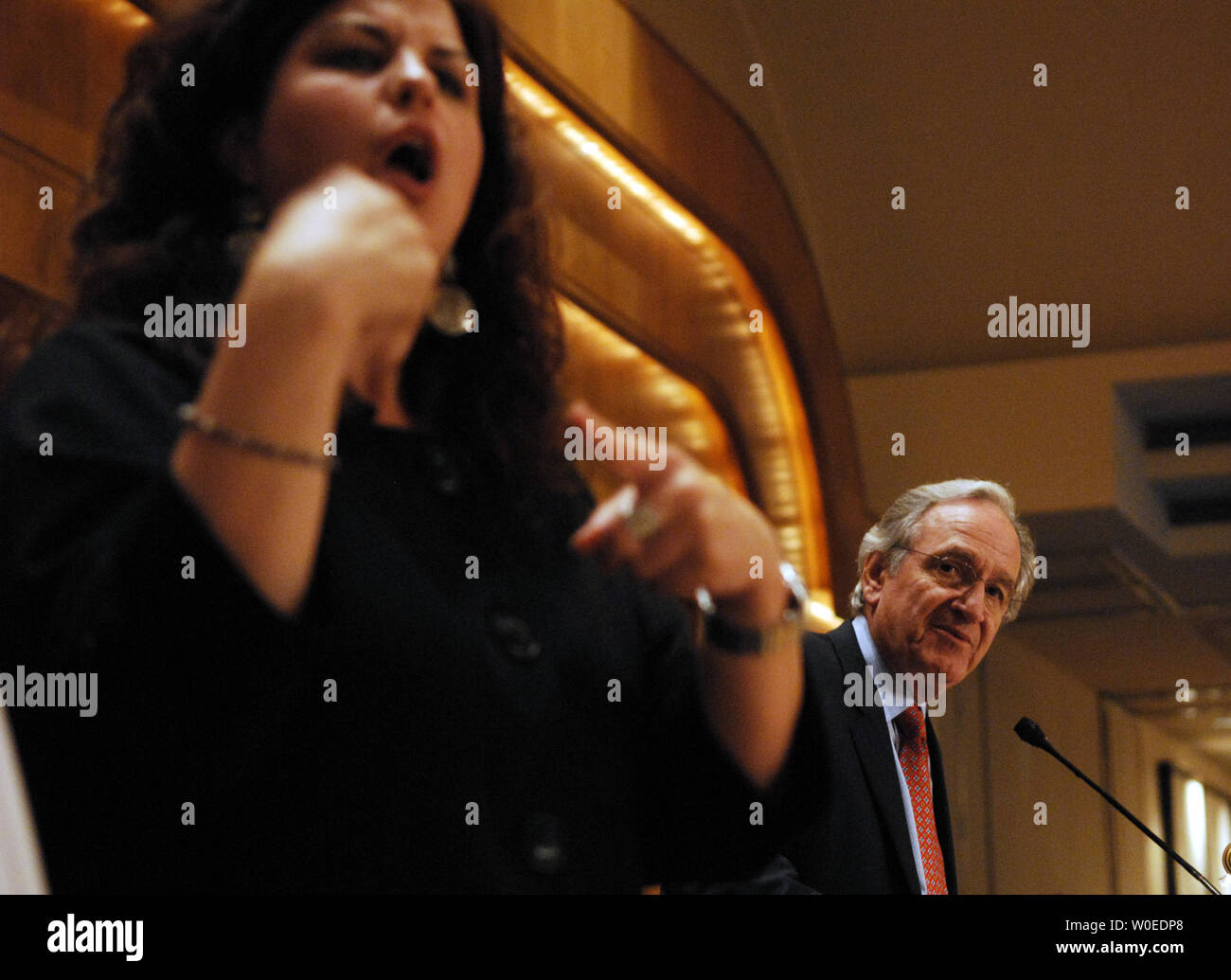 Sen. Tom Harkin (D-IA) speaks, as an interpreter (L) signs his words ...