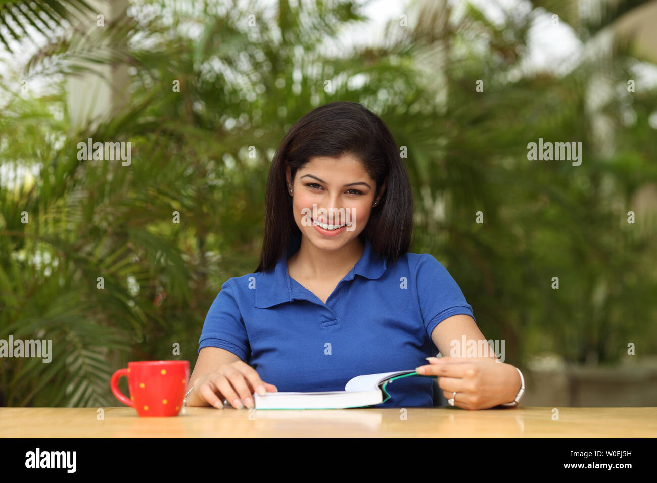 Indian college student reading a book Stock Photo - Alamy