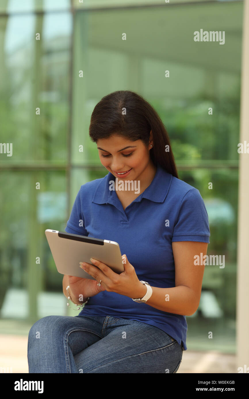 Indian college student using a digital tablet and smiling Stock Photo ...