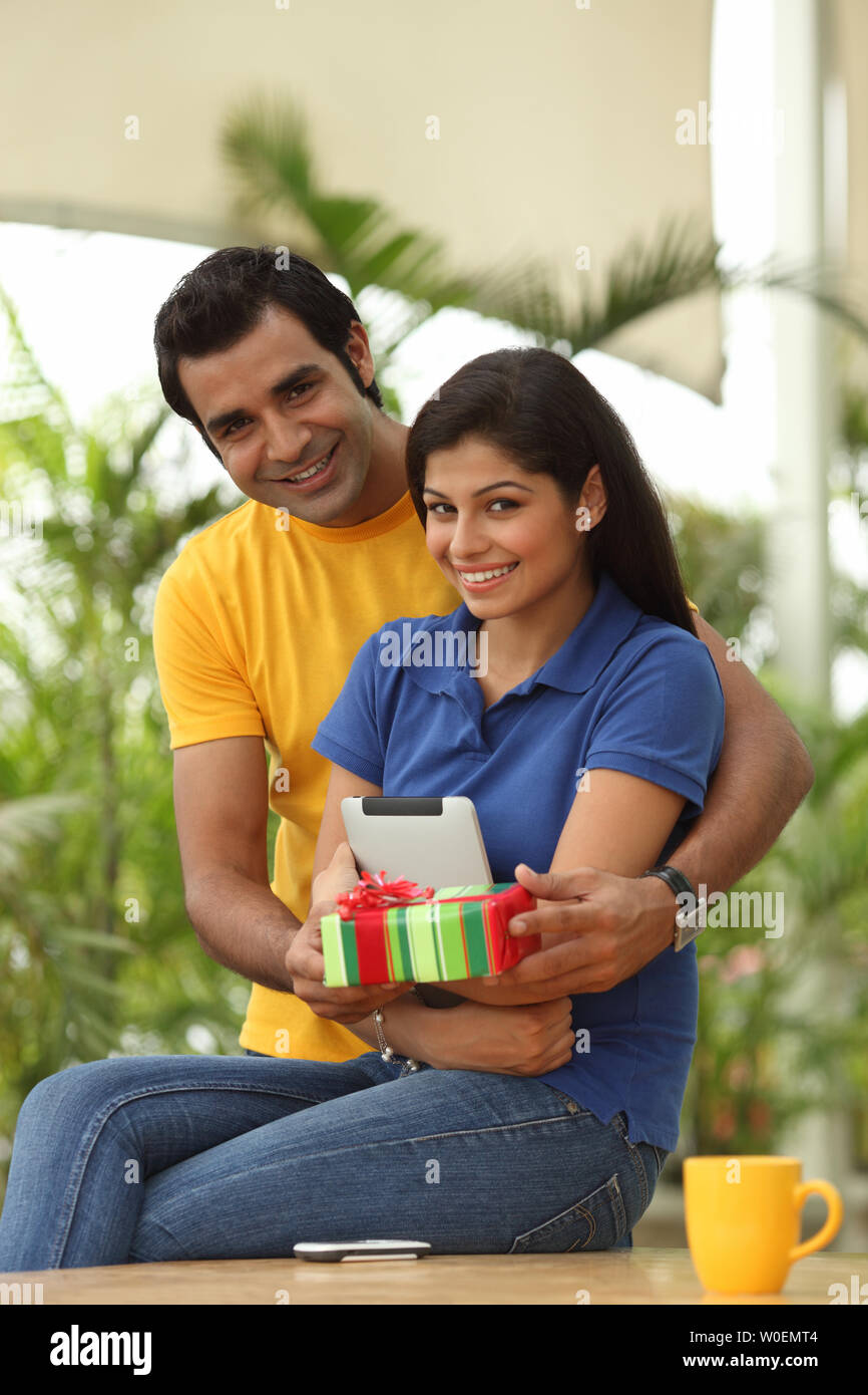 Man giving a gift to a woman Stock Photo - Alamy
