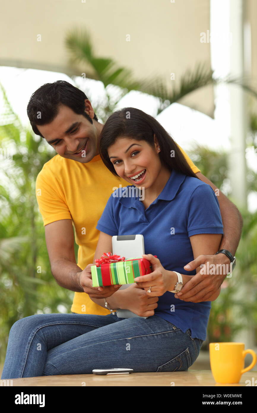 Man giving a gift to a woman Stock Photo - Alamy