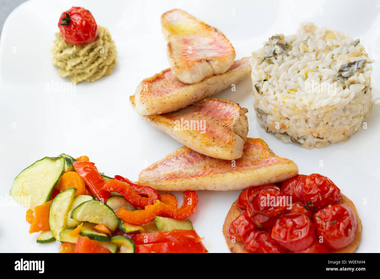 Presentation of a Mediterranean plate with fillets of red mullet, rice ...