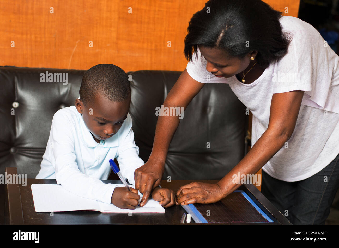 Mom shows her child where he has to write in his notebook Stock Photo ...