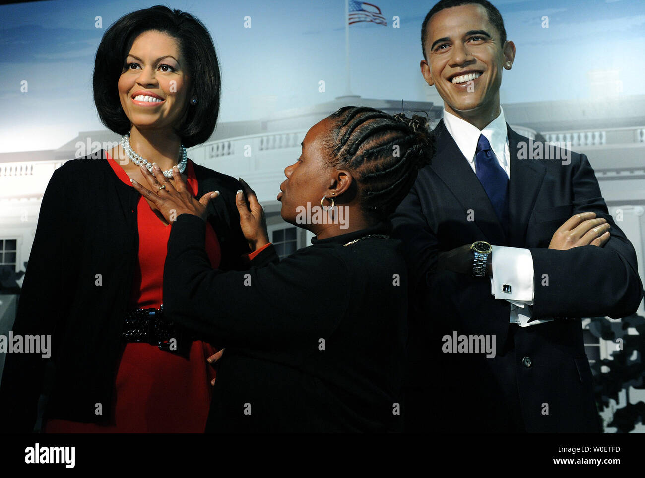 Tourists are photographed with wax figures of First Lady Michelle Obama ...