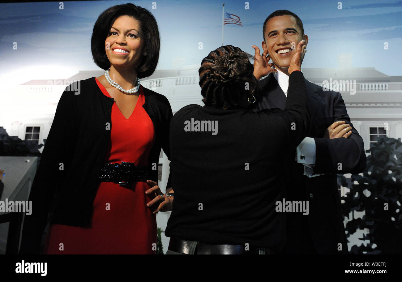 Tourists are photographed with wax figures of First Lady Michelle Obama ...