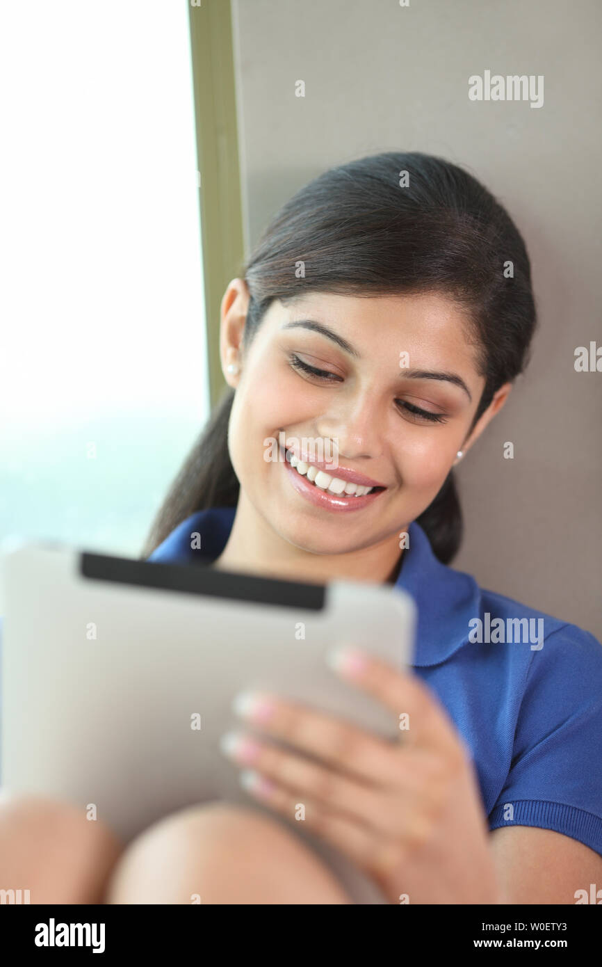 Indian young woman using a digital tablet Stock Photo - Alamy