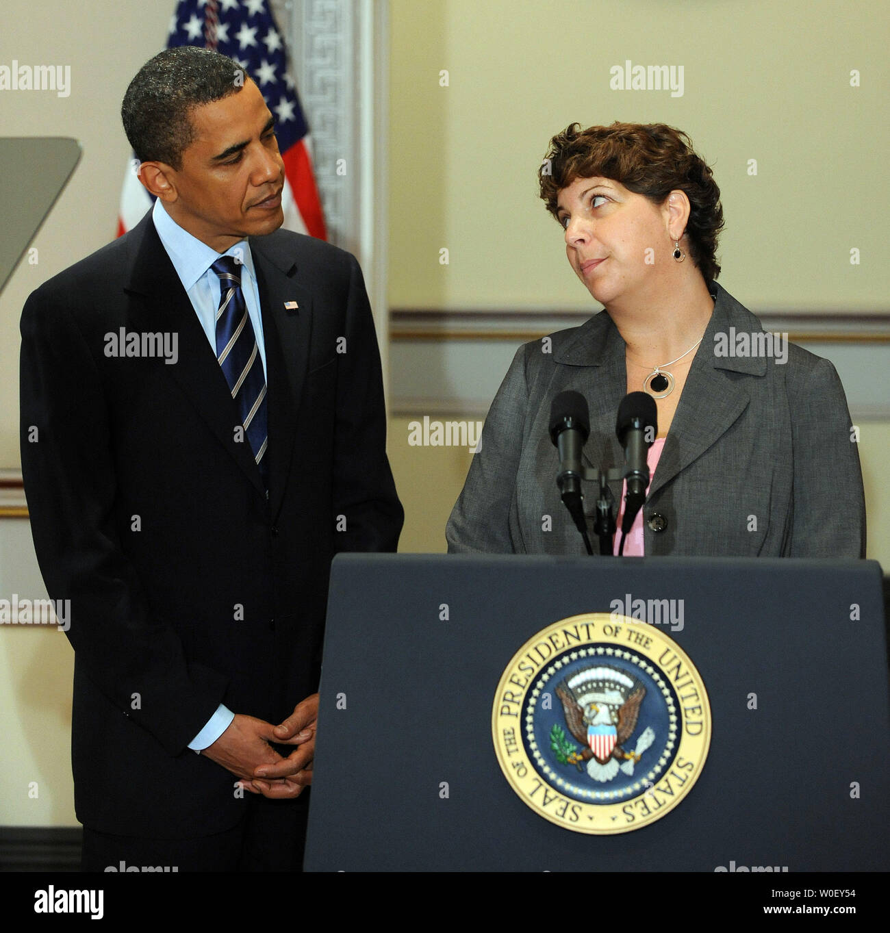 U.S. President Barack Obama looks on as Maureen Pike tells her story of ...