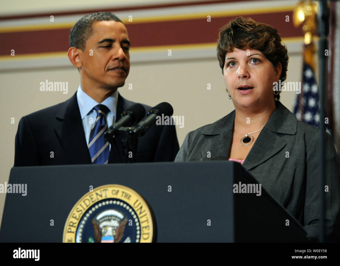 U.S. President Barack Obama looks on as Maureen Pike tells her story of ...