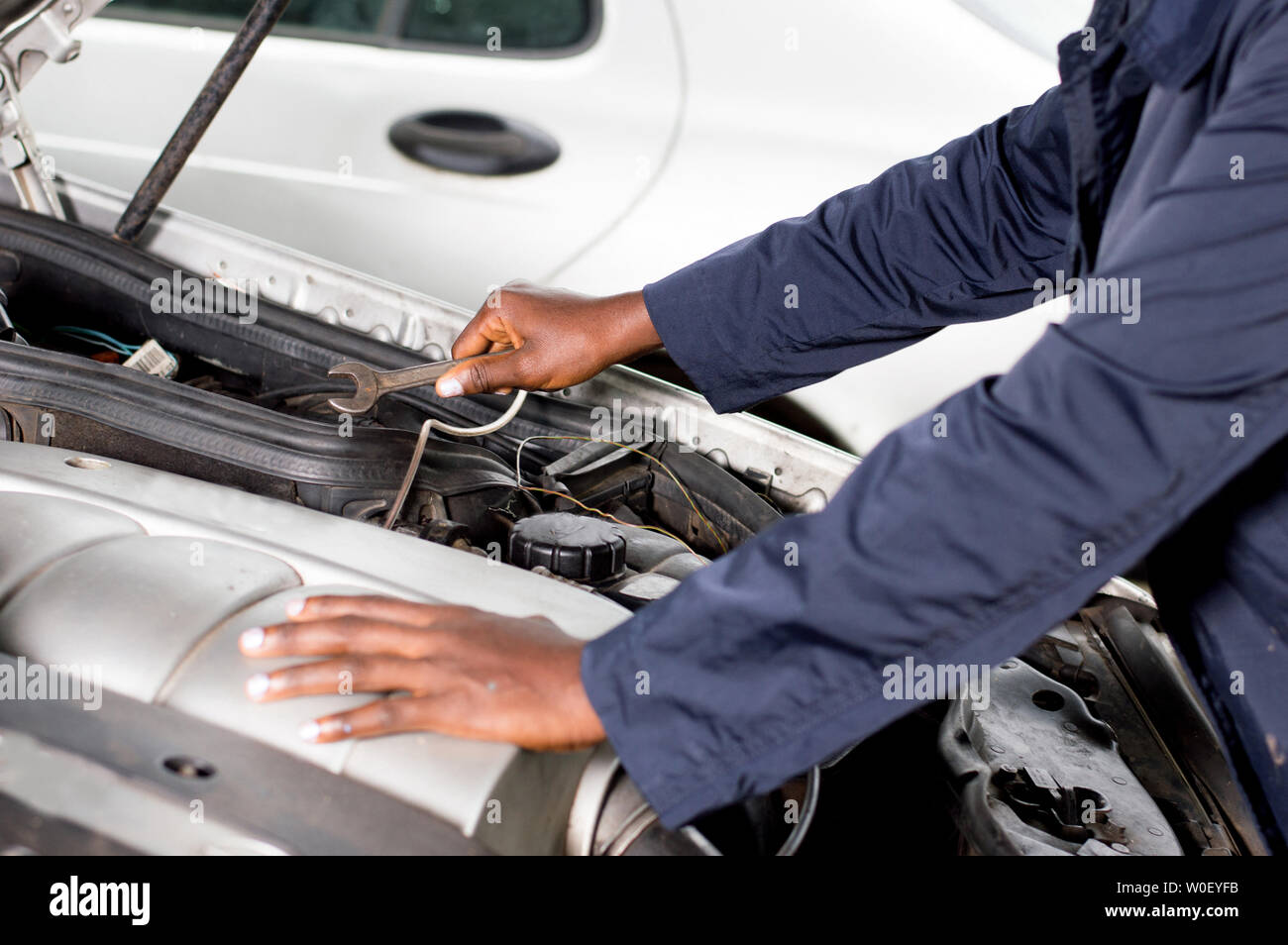 Closeup of a hand holding a key on the engine of a broken car Stock ...