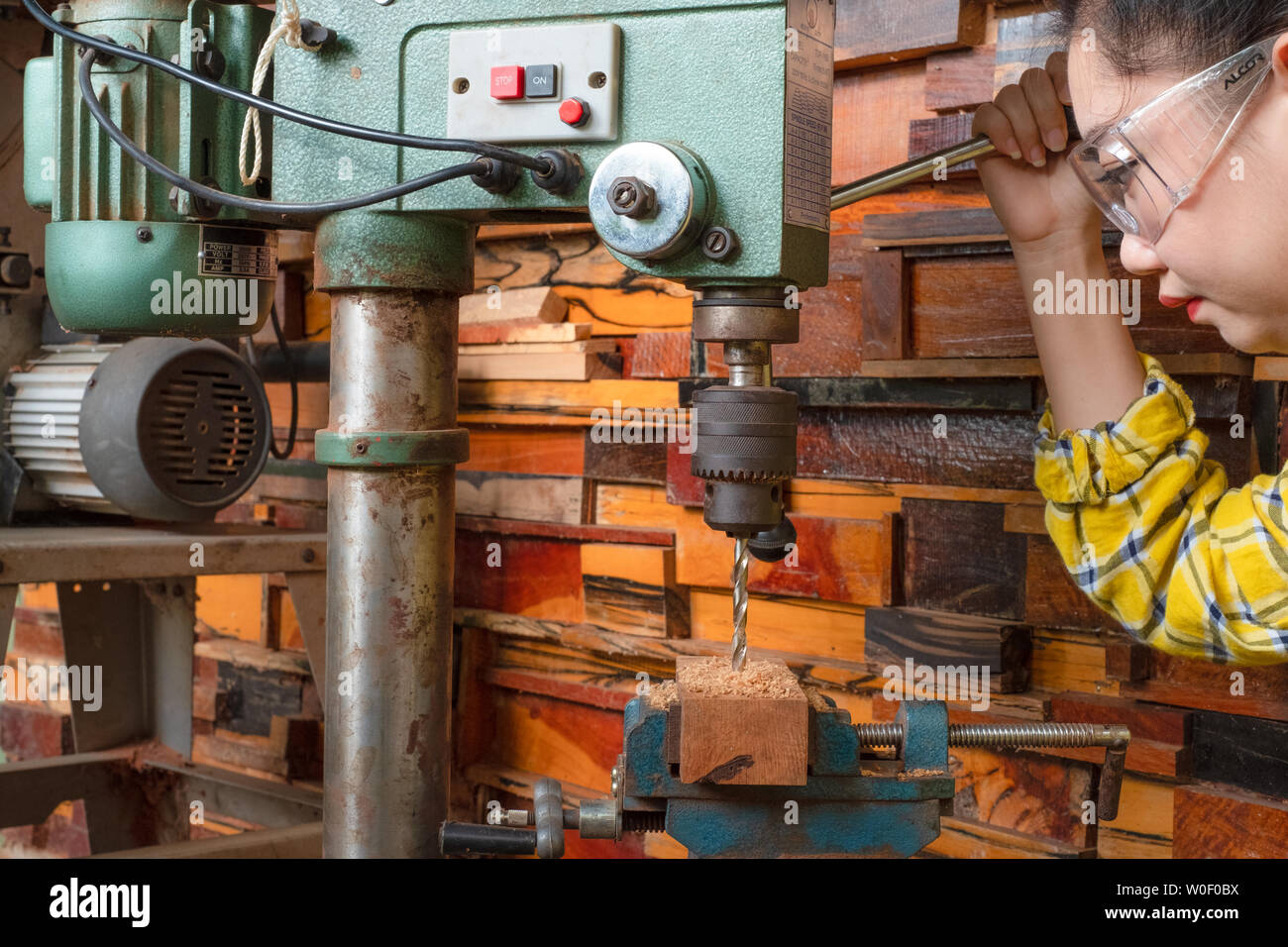 Women standing is craft working drill wood at a work bench with Drill ...