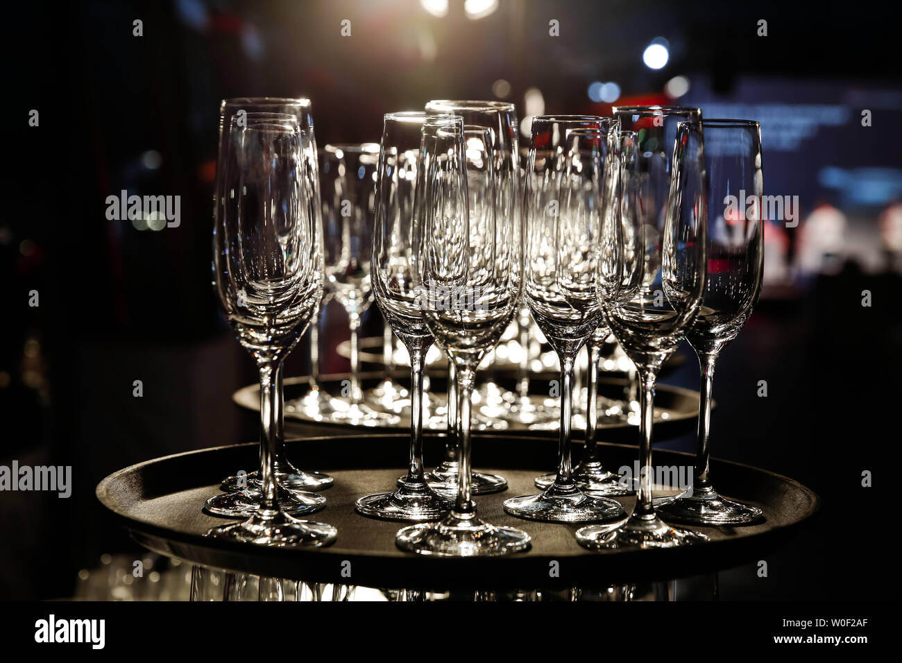A bunch of empty champagne flutes on tablets stacked on each other with ...