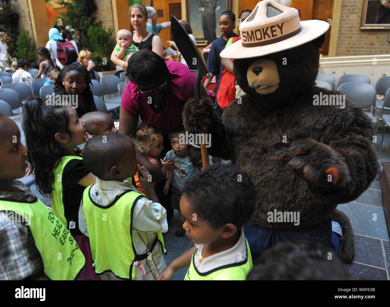 An actor dressed as Smokey the Bear greets children at a ceremony ...