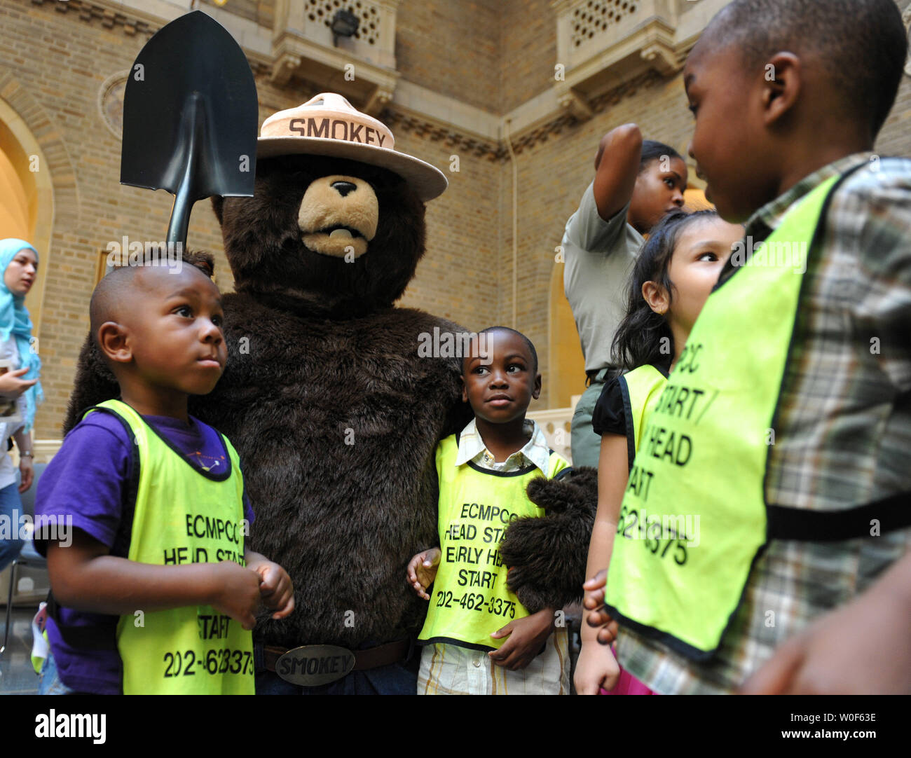 An actor dressed as Smokey the Bear greets children at a ceremony ...