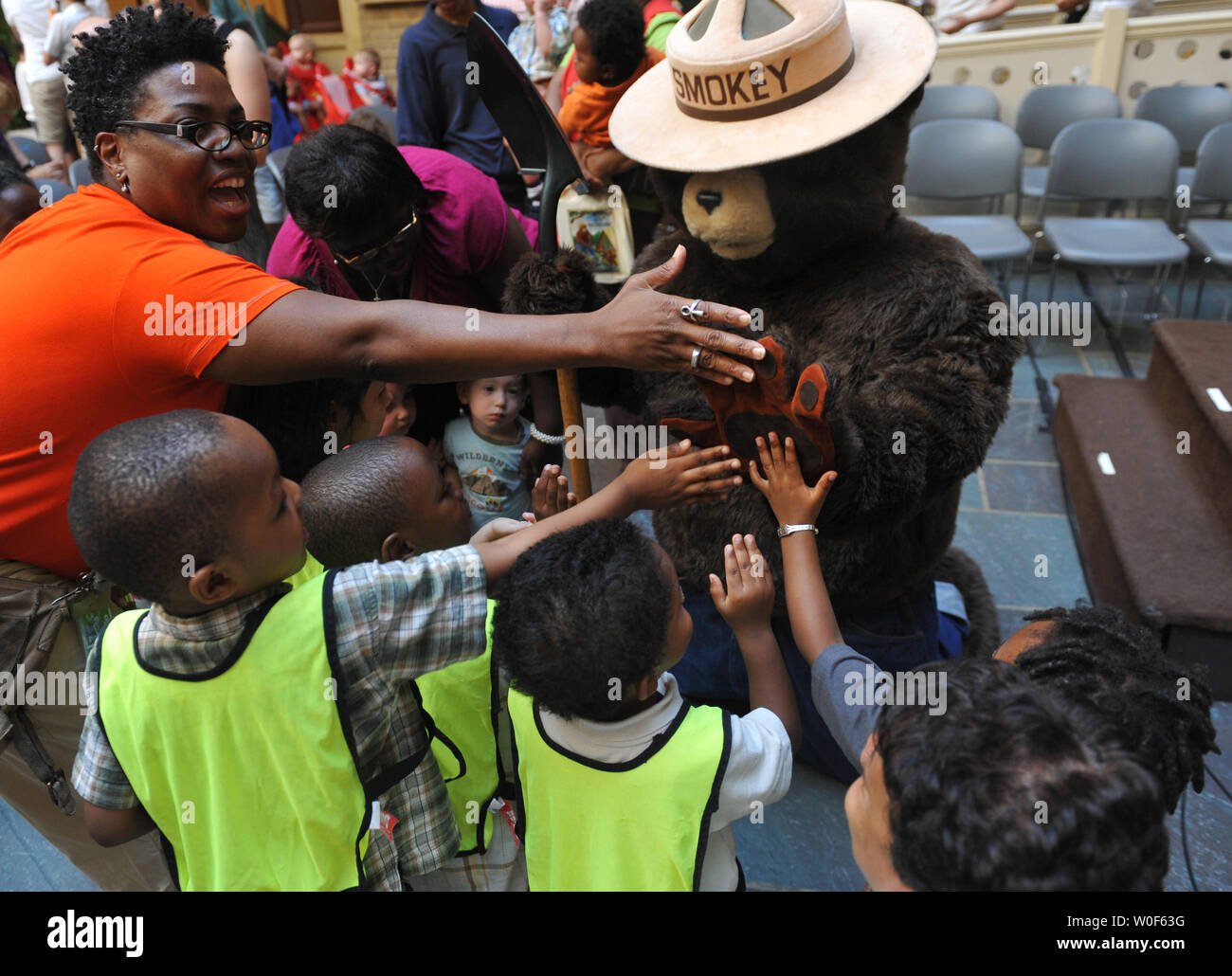 An actor dressed as Smokey the Bear greets children at a ceremony ...