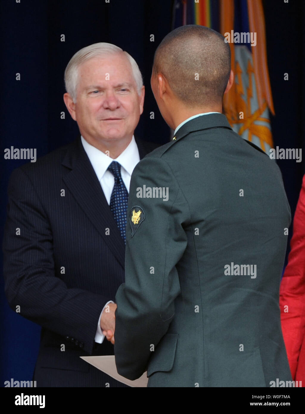 Secretary Robert Gates (L) congratulates a member of the military who ...