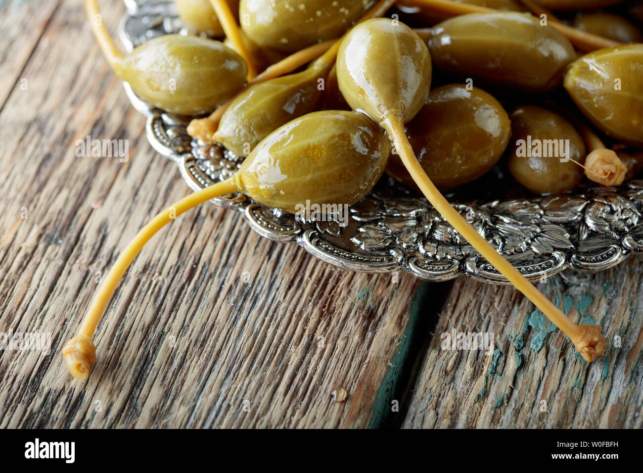 Pickled caper berries in metal dish . Edible fruits of Capparis ...