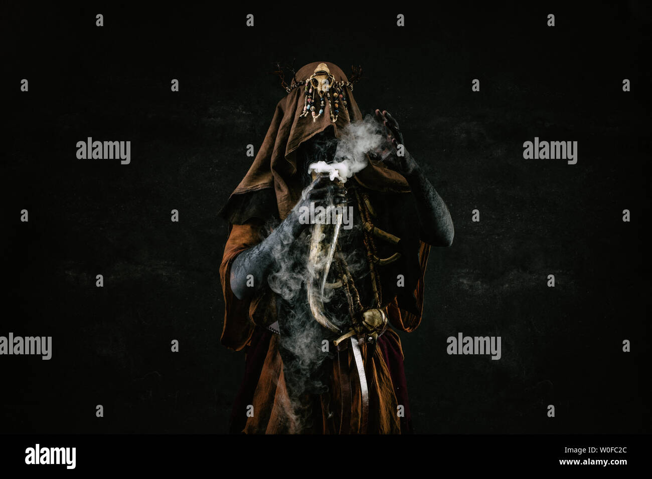 Portrait of a shaman holding a steaming horn Stock Photo - Alamy