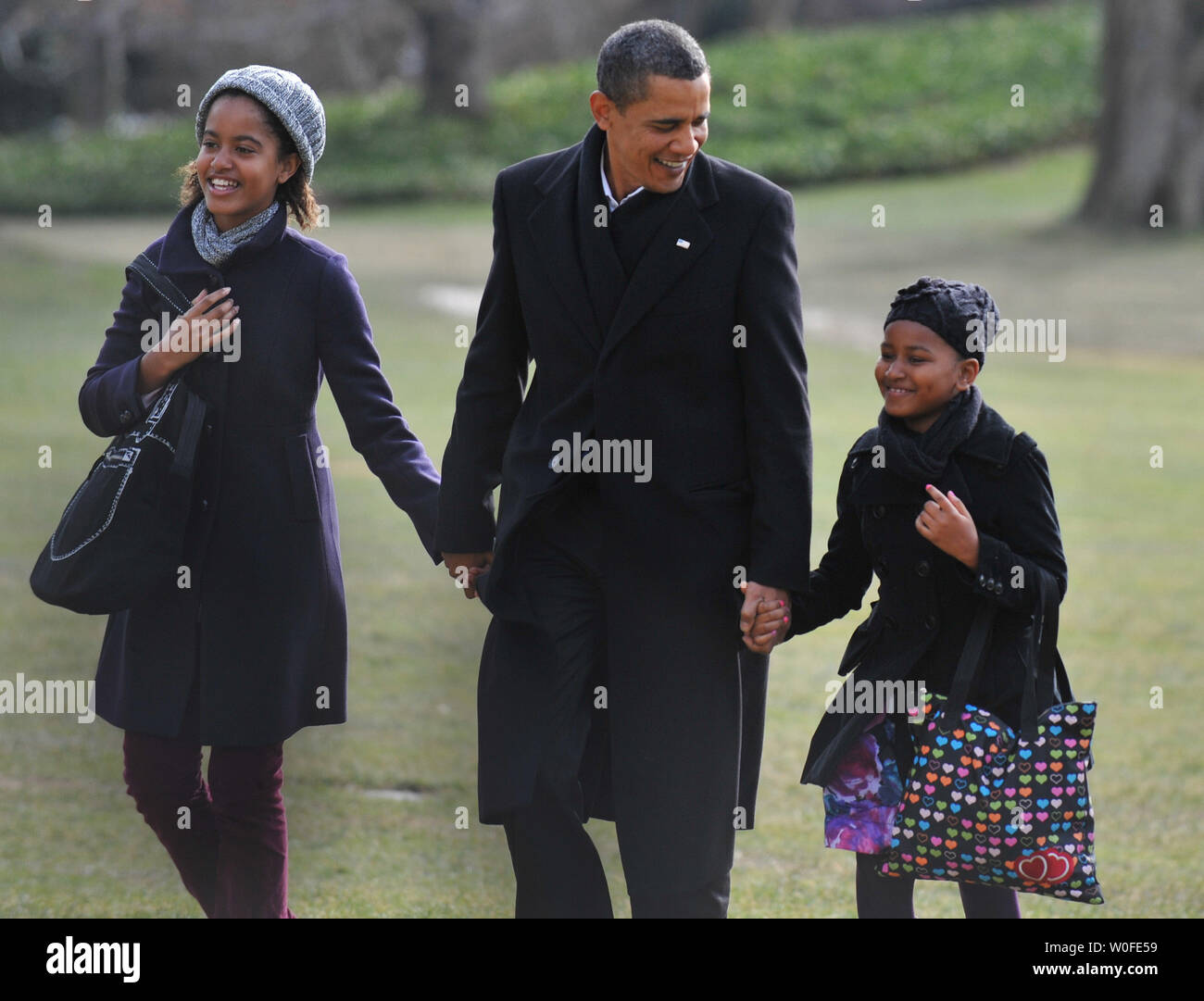 President Barack Obama walks with his daughters Sasha (R) and Malia as ...