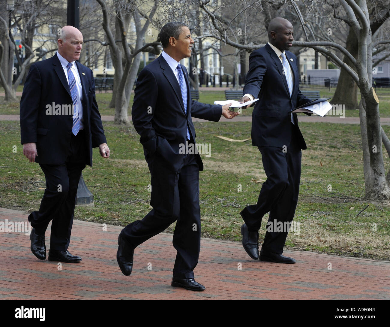 U.S. President Barack Obama (C) walks with aide Reggie Love (R) and a ...