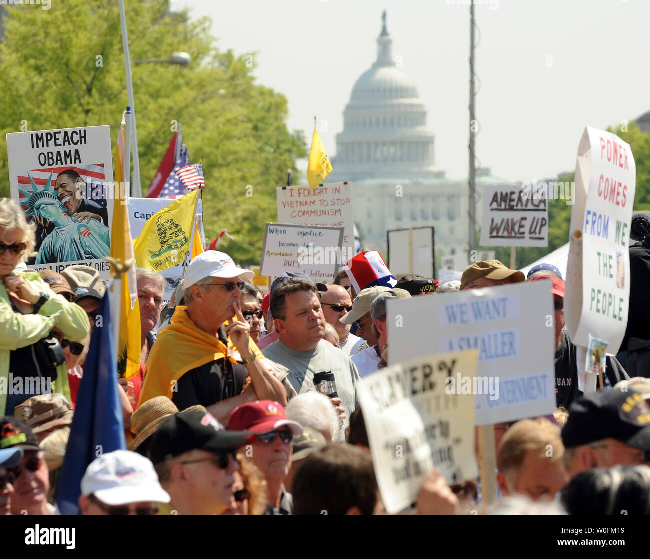 Demonstrators holds signs at a Tea Party rally at Freedom Plaza on tax ...
