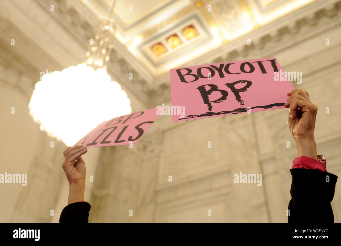 Protestors hold up signs against BP during a Senate Energy and Natural ...