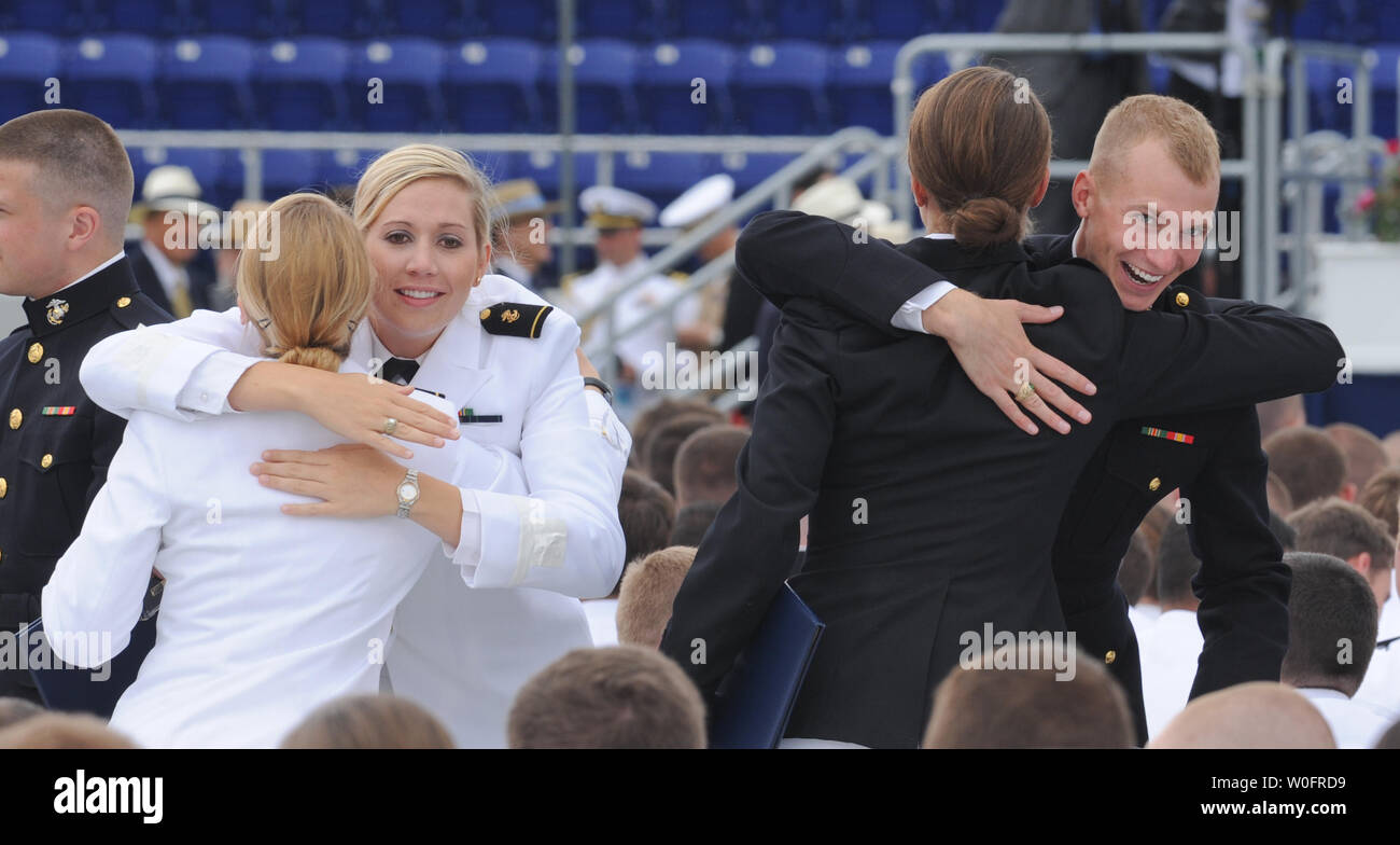 Graduates hug after receiving their diplomas at the U.S. Naval Academy ...