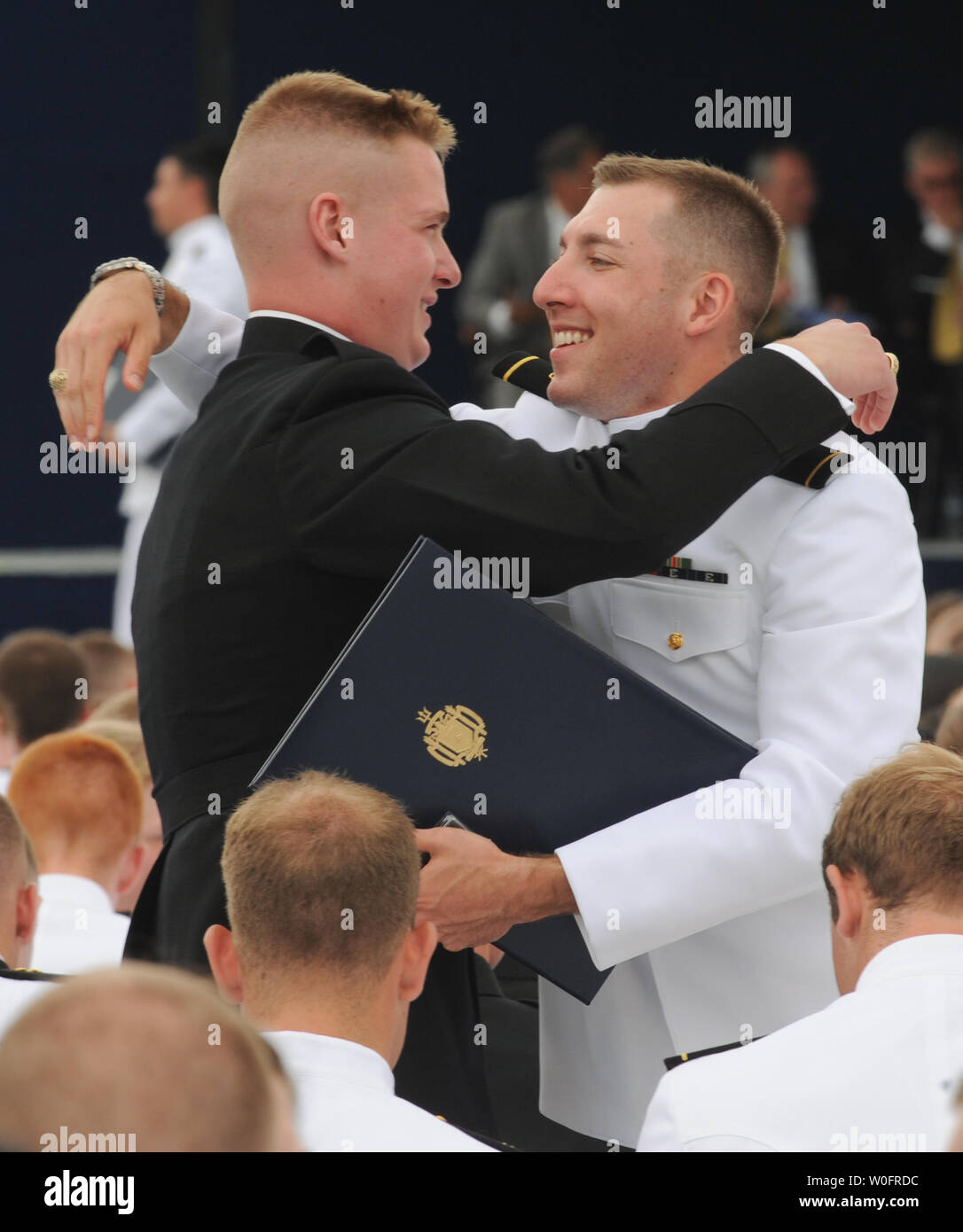 Graduates hug after receiving their diplomas at the U.S. Naval Academy ...