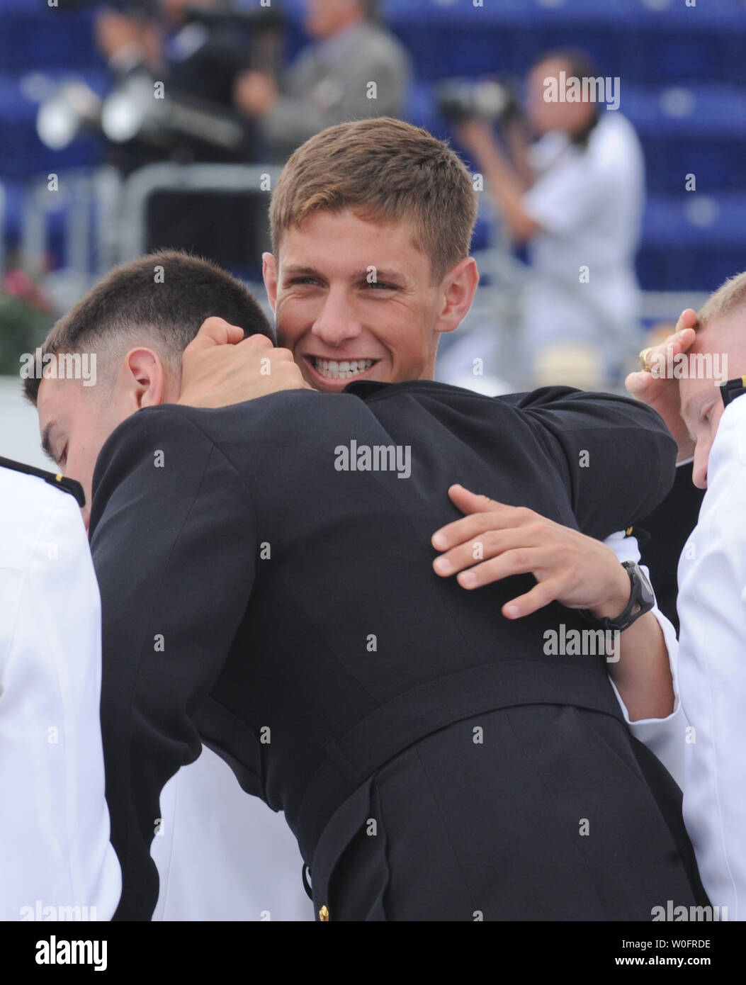 Graduates hug after receiving their diplomas at the U.S. Naval Academy ...