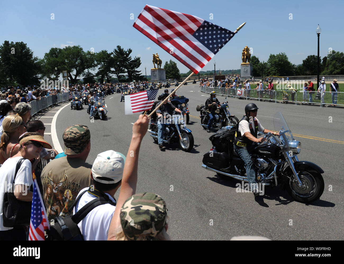A woman waves a flag as motorcyclists cross the Memorial Bridge in the Rolling Thunder XXIII ...
