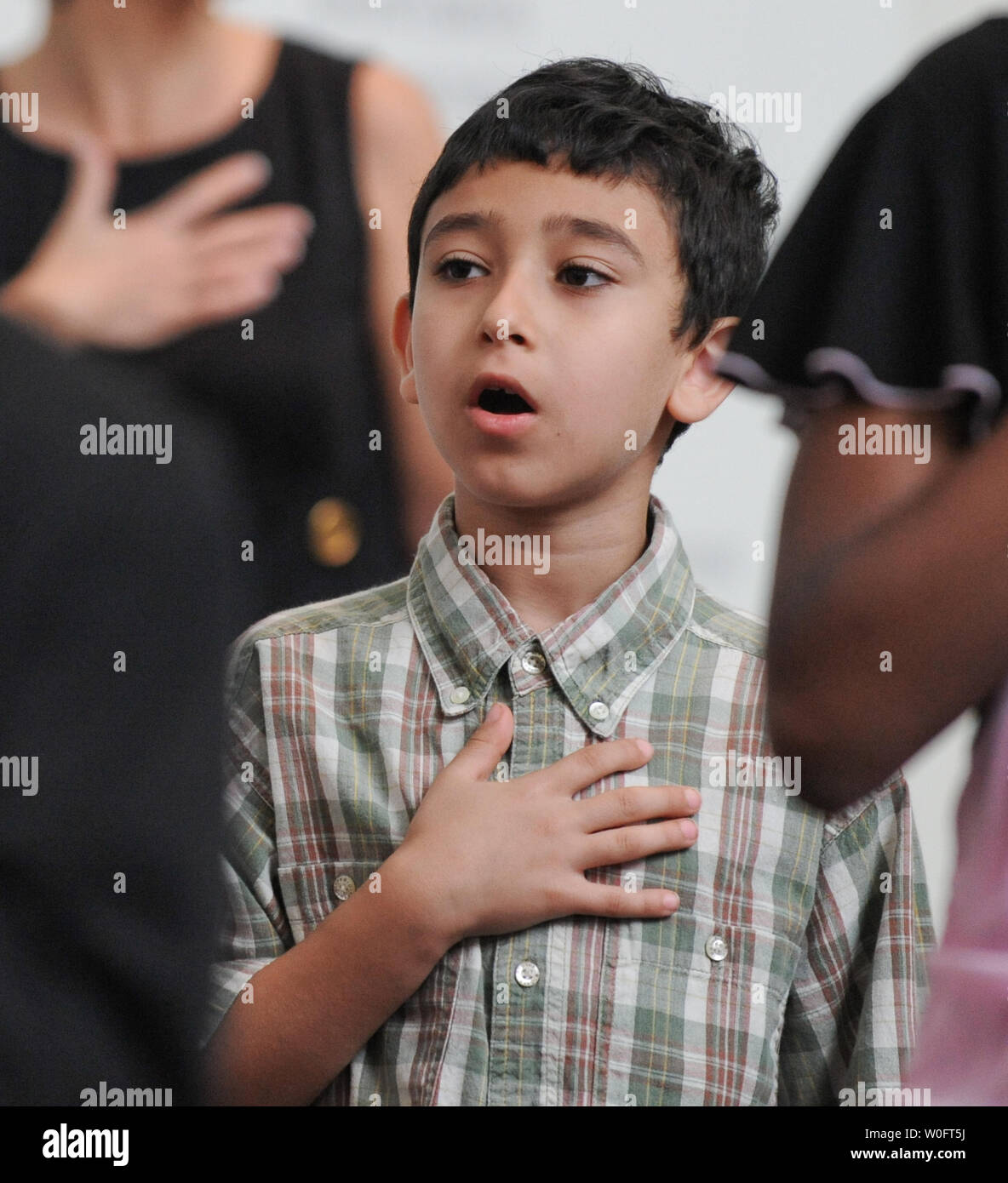 A child says the Pledge of Allegiance as 24 children representing 18 ...
