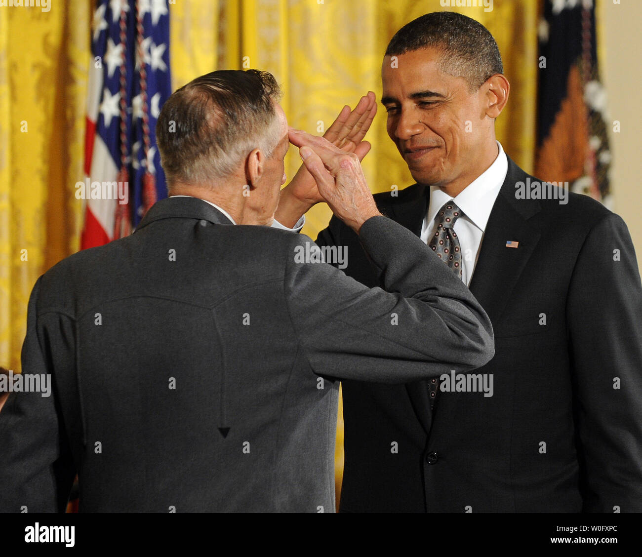 U.S. President Barack Obama salutes George Weiss, Jr., a veteran of ...