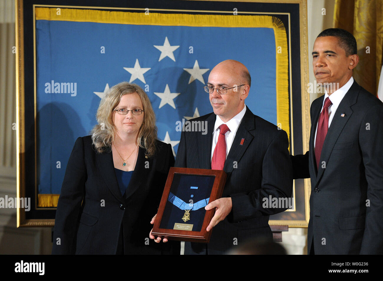 President Barack Obama puts his arm on Paul and Maureen Miller after ...