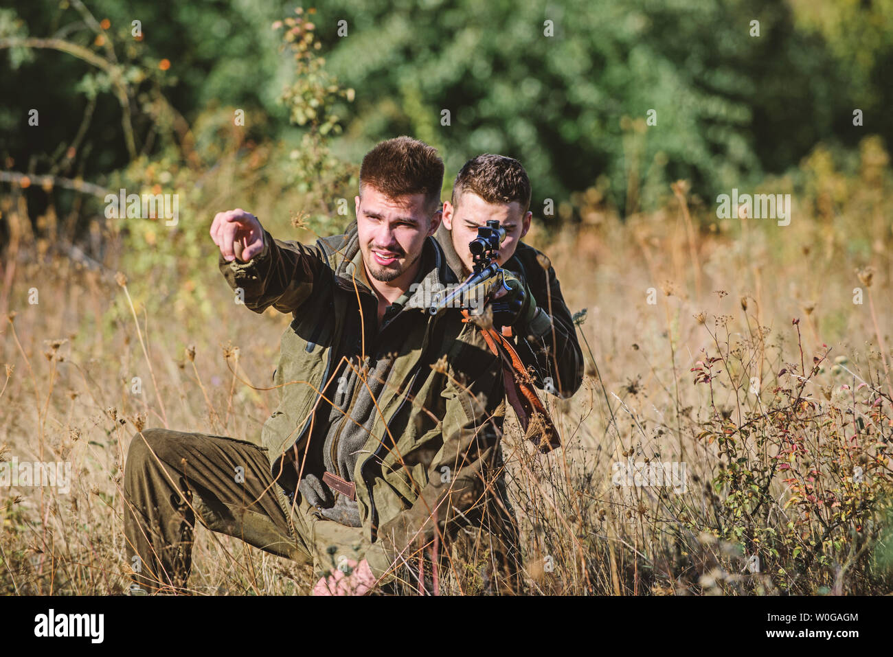 Hunters with rifles in nature environment. Hunters gamekeepers looking ...
