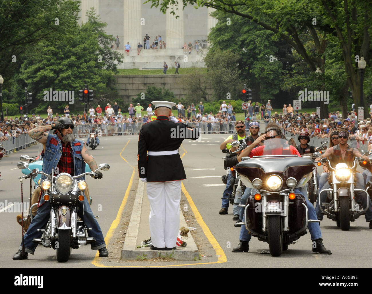 Bikers salute USMC SSgt. Tim Chambers who stands in the middle of the street as motorcycles roar ...