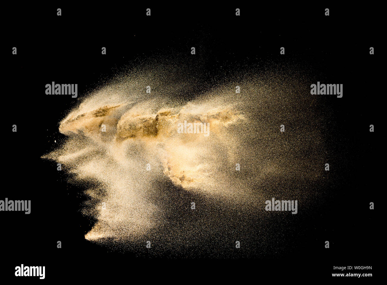 Dry sand explosion. Brown colored sand splash against black background ...