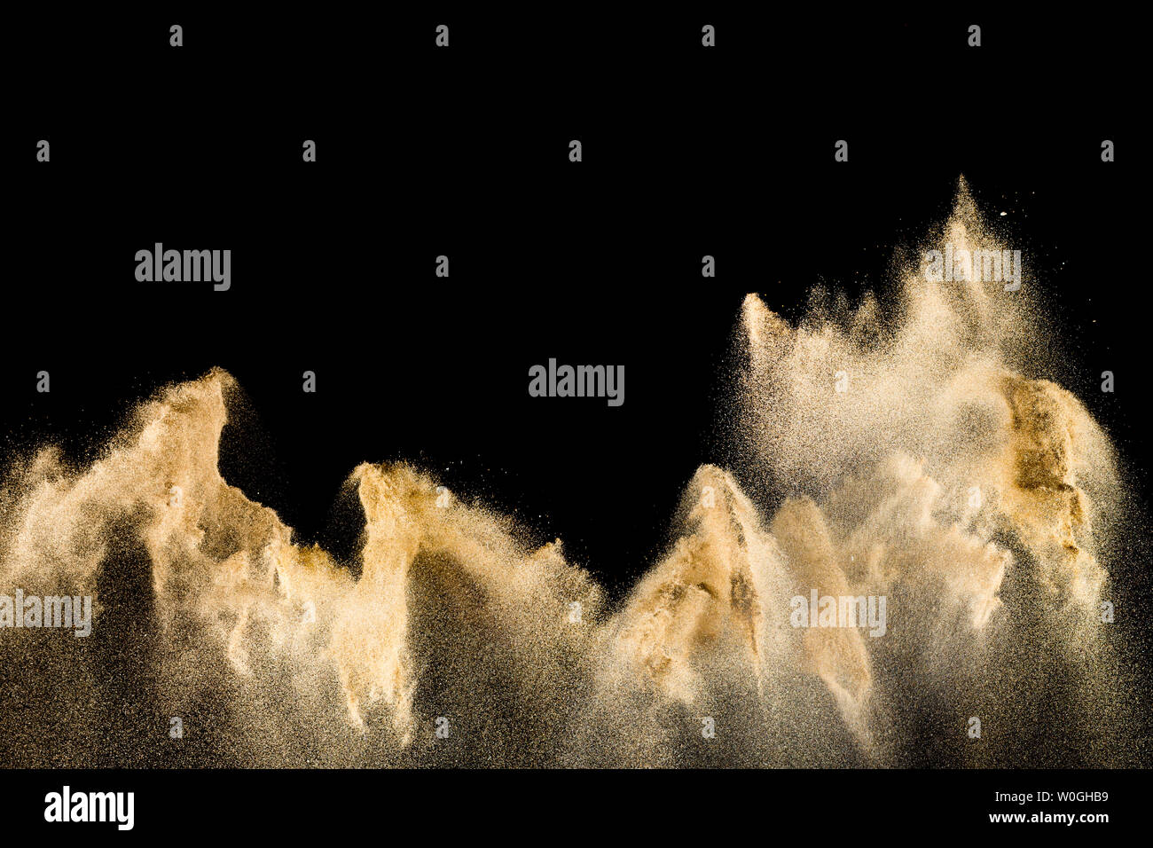 Dry sand explosion. Brown colored sand splash against black background ...