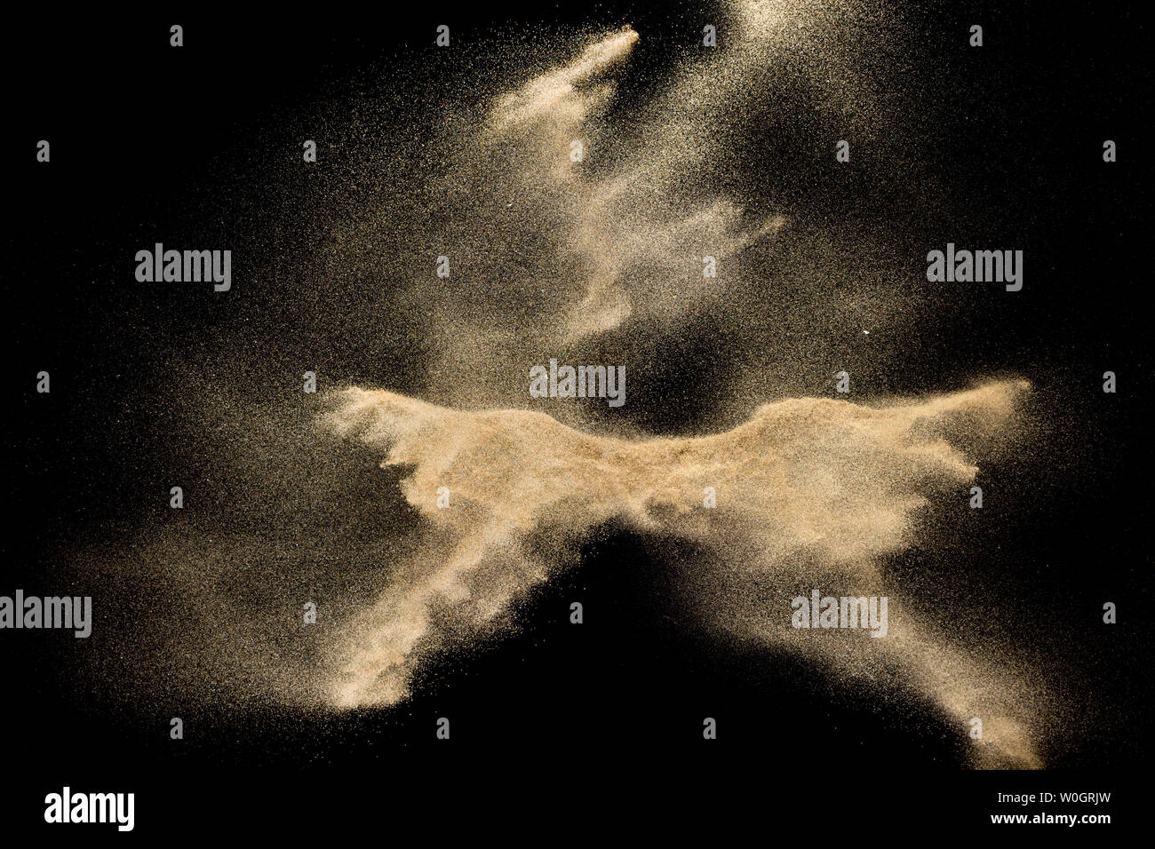 Dry river sand explosion. Golden colored sand splash against black ...