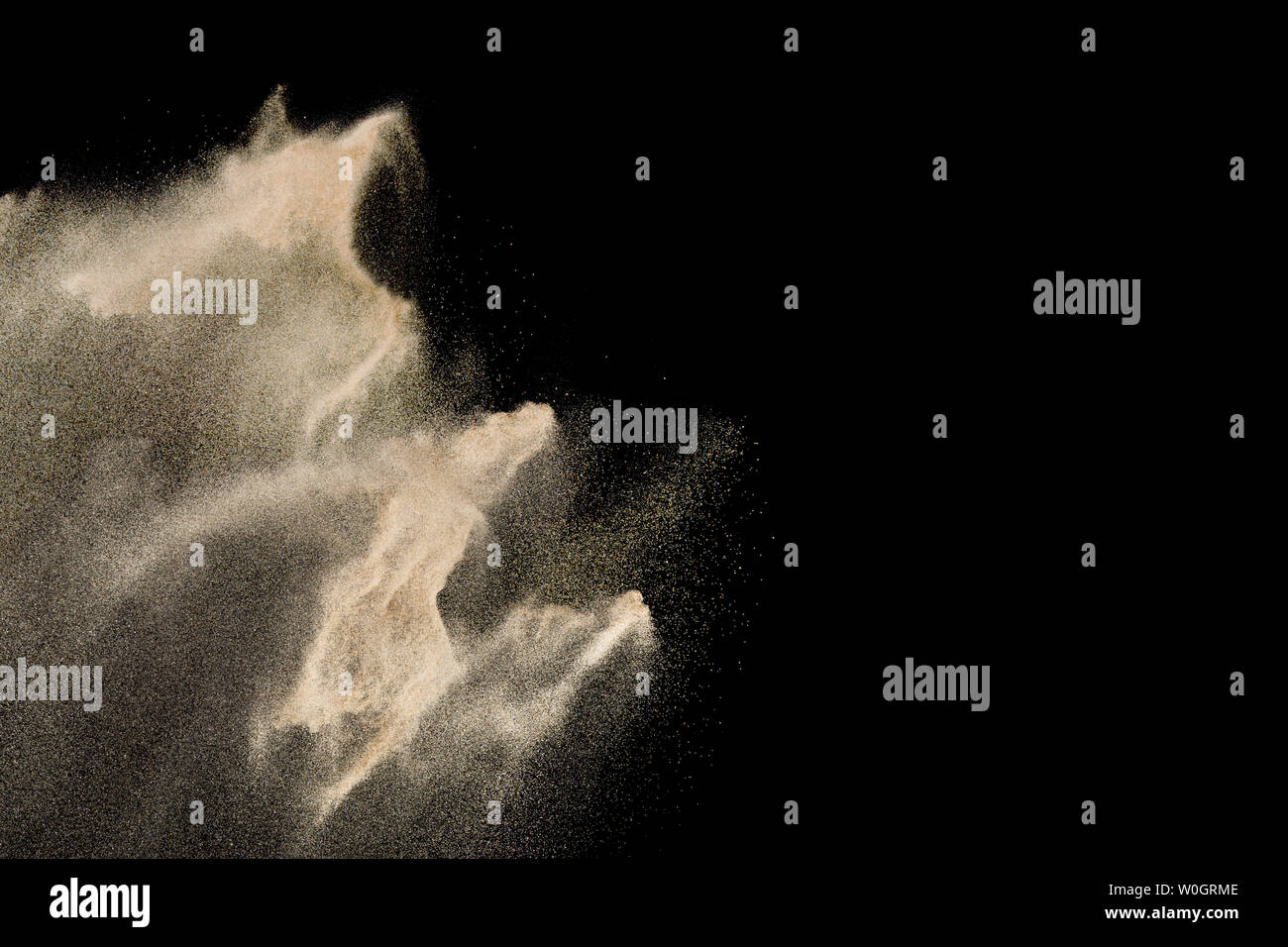 Dry river sand explosion. Golden colored sand splash against black ...