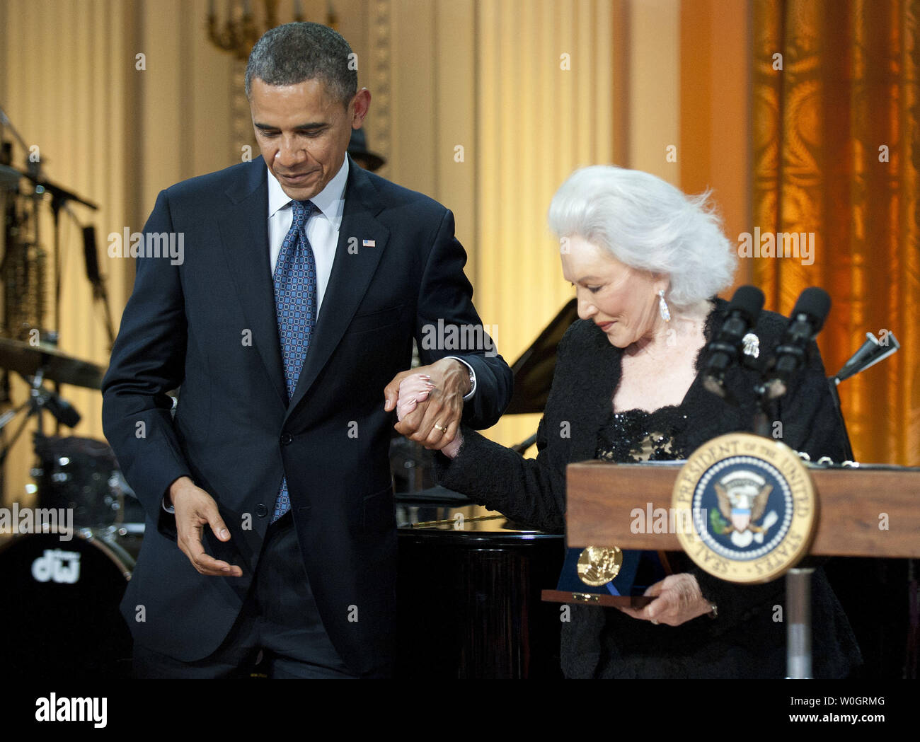 President Barack Obama helps Eunice David, the wife of musician Hal ...