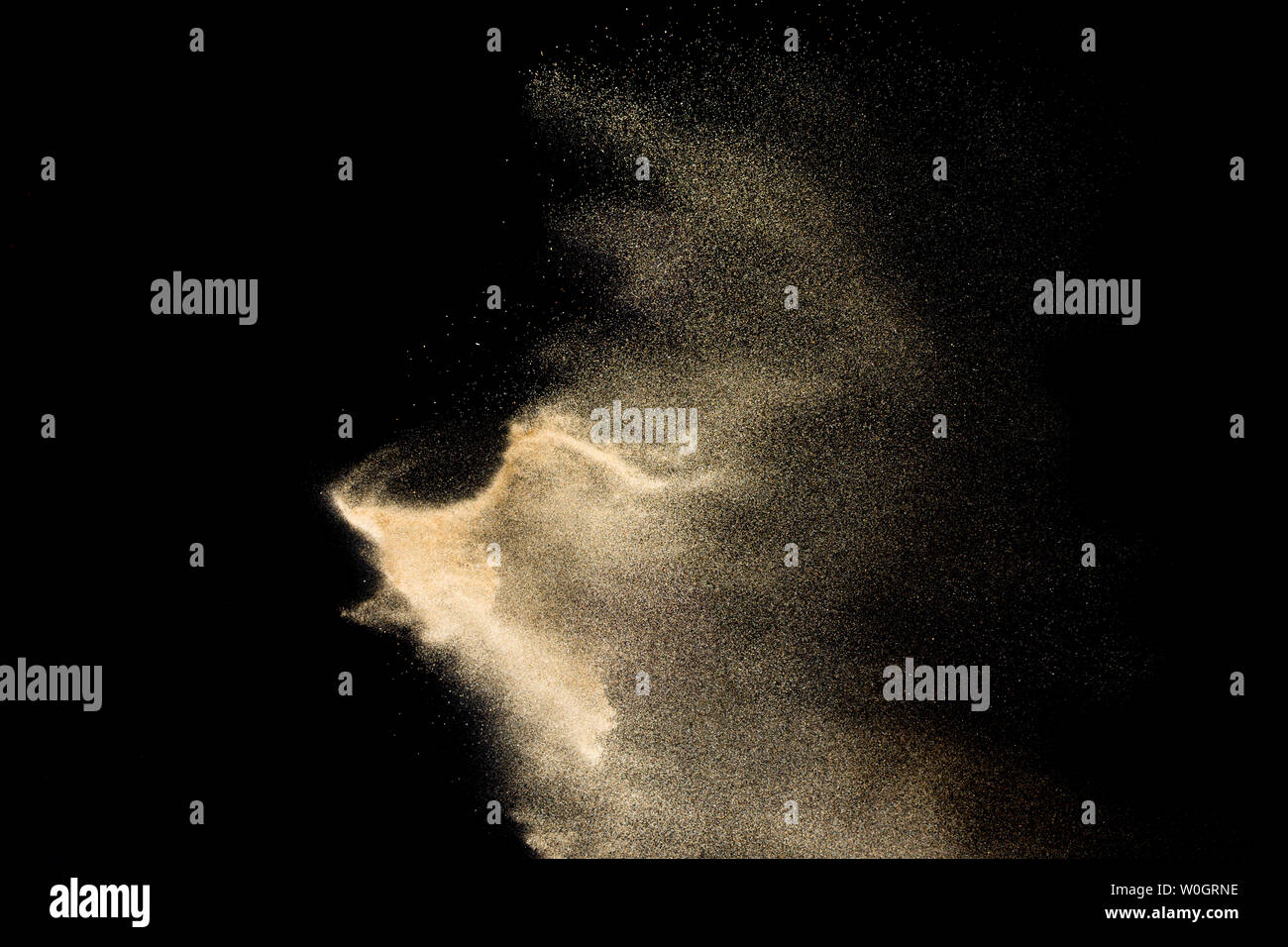 Dry river sand explosion. Golden colored sand splash against black ...