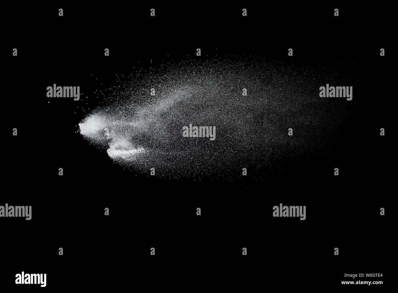 Freeze motion of white dust particles on black background. White powder ...